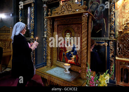 A Romanian woman praying inside St. Antony's Orthodox Church, known as ...