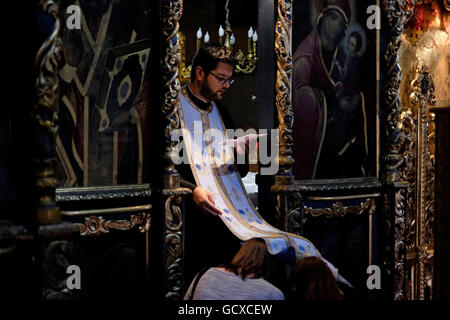 A Romanian Orthodox priest gives blessings to believers inside St ...