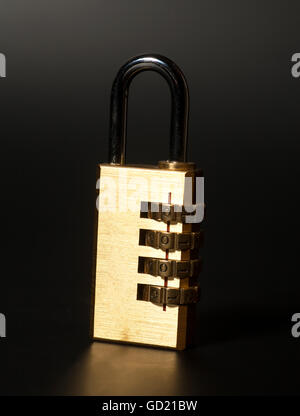 Closeup of a gold combination padlock on a laptop. Focus on combination ...