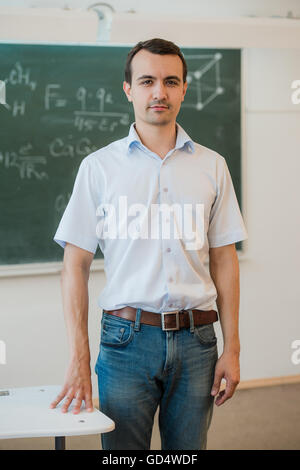 Handsome male teacher with chalk against brick wall Stock Photo - Alamy