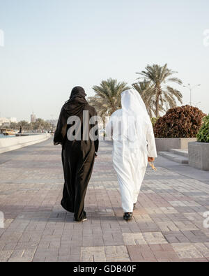 Local couple take a stroll along Doha's corniche Stock Photo - Alamy