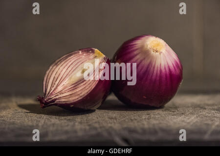 Food still life with red onion in bowl and shallot on stone table in ...