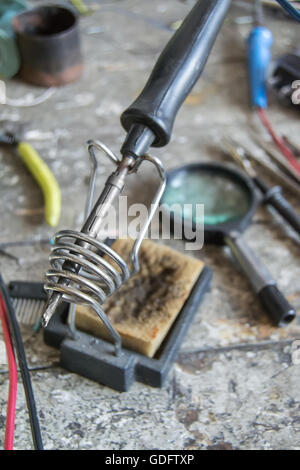 closeup old soldering iron on wooden desk Stock Photo - Alamy