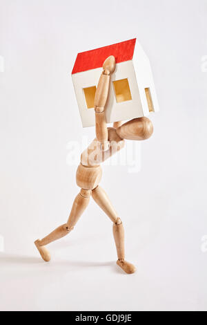 Dummy carrying small house on white background Stock Photo - Alamy