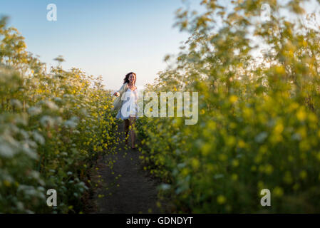Woman walking through field of wildflowers Stock Photo - Alamy