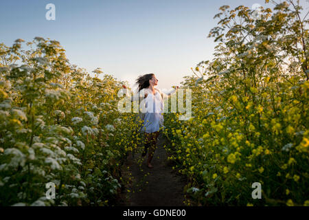 Woman walking through field of wildflowers Stock Photo - Alamy