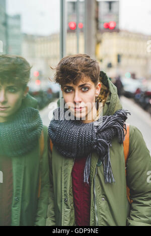 Young woman leaning against a window, portrait Stock Photo - Alamy