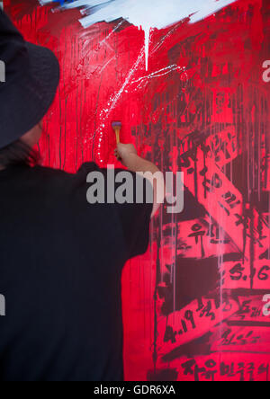 North korean artist sun mu in frot of a painting with donald trump and ...