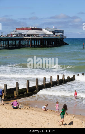 The beach at Cromer in Norfolk England UK at dusk with the sun setting ...