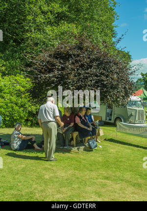 A group of people sheltering under a tree from the rain Stock Photo - Alamy