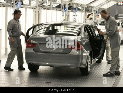 BMW 1 and 3 Series on an assembly line move past office-workers at the ...