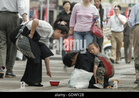 A Chinese beggar begs with a kid on a street Stock Photo - Alamy