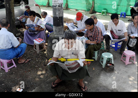 MYANMAR. Yangon. 2015. Newspaper readers Stock Photo - Alamy