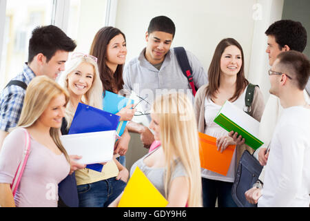 Happy group of friends studying and talking together at university ...