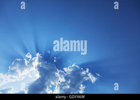 Sun slanting among from white clouds. Nature background Stock Photo - Alamy
