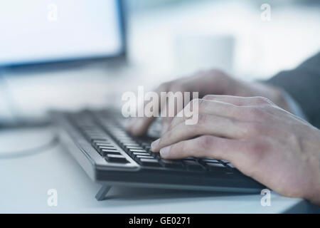 cropped image of businessman typing on computer keyboard in office ...