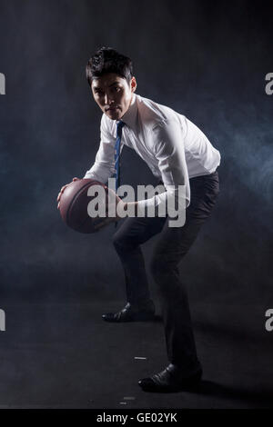 Business man posing with a basketball staring at front Stock Photo - Alamy