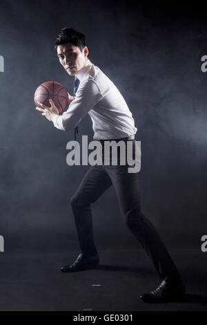 Business man posing with a basketball staring at front Stock Photo - Alamy