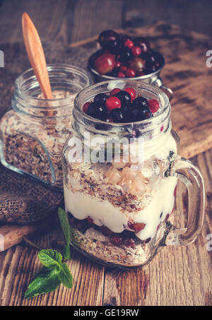 Wooden retro spoon in a jar full of plum jam on a desk. Close up ...