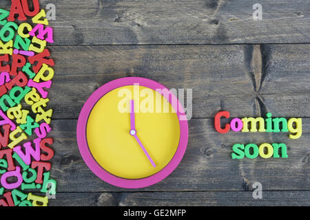 Coming Soon alphabet letter and alarm clock on wooden background Stock ...