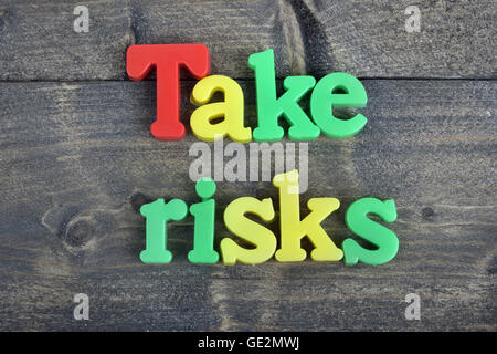 Take risks word on wooden table Stock Photo - Alamy