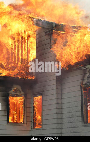 House on fire. Flames and smoke destroy and burn isolated old wood ...