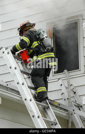 A firefighter climbing a ladder Stock Photo - Alamy