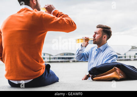 Two colleagues having a beer after work Stock Photo - Alamy
