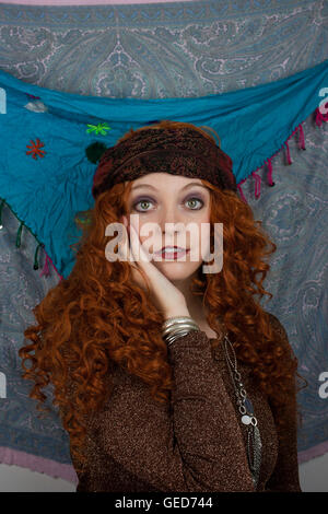 Beautifiul young woman with long curly red hair dressed as a gypsy ...