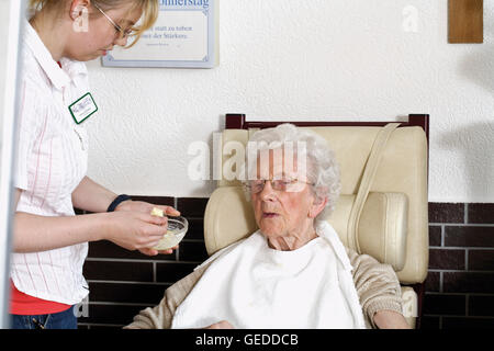 Caregiver feeding an elderly woman at a nursing home Stock Photo - Alamy