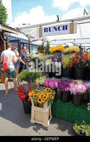 London, England, UK. Hackney. Netil Market. Queue of people waiting to ...