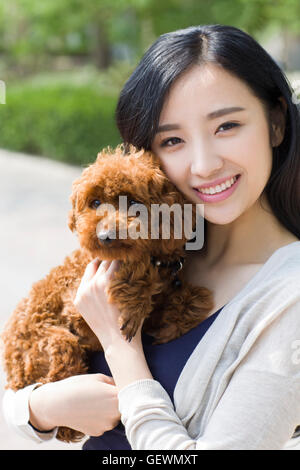 Asia women and dog happy smile with love kissing her pat is a dog so ...