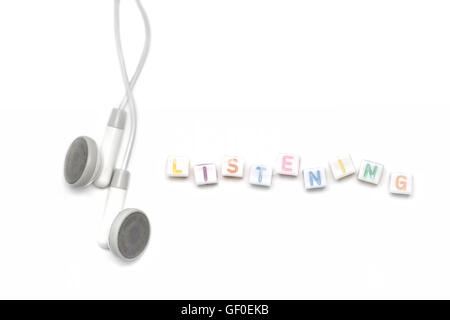 white earbuds with alphabet listening on cube shape Stock Photo - Alamy