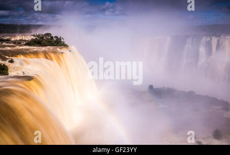 A rainbow forms above the Iguacu Falls as giant amounts of water fall ...