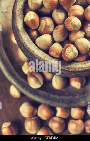 Hazelnuts in rustic round clay bowl on wooden background Stock Photo ...