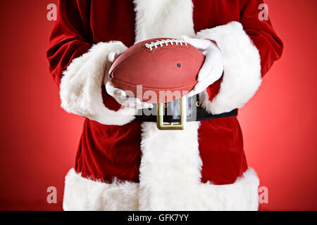 Anonymous Santa Claus on a red background holding various props, gifts ...