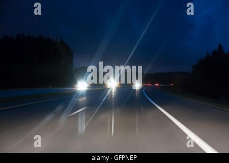 oncoming cars on highway in twilight time Stock Photo - Alamy