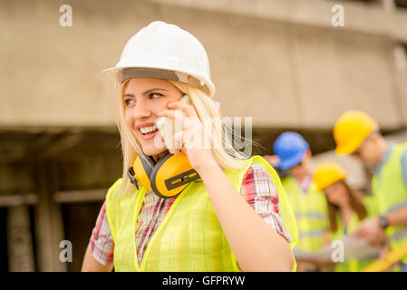 Female building contractor using smart phone at construction site Stock ...