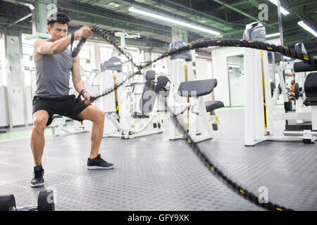 Young man exercising with battling rope at gym Stock Photo: 112667739 ...