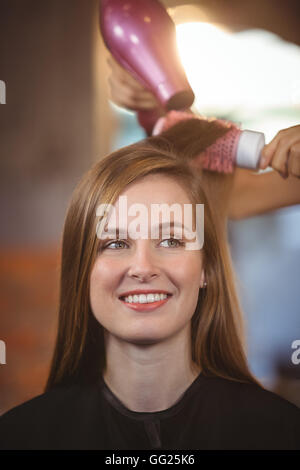 Hairdresser smiling and styling customers hair Stock Photo - Alamy