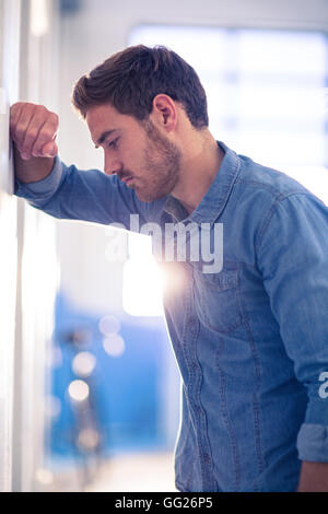 Tired businessman leaning on wall and rubbing eyes in London city Stock ...