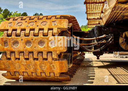 Large commercial crane tracks showing hydraulic hoses against blue sky ...