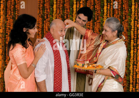 Woman applying tika on her husband forehead Stock Photo - Alamy