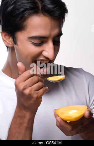 Indian man eating mango Stock Photo - Alamy