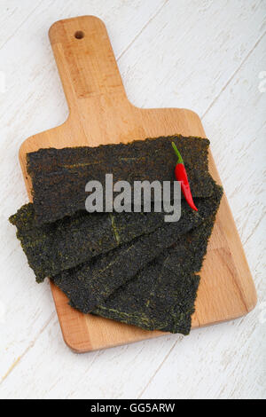 Spicy Nori seaweed sheets with pepper on wood Stock Photo - Alamy