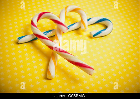 Sweet candy canes on yellow background, space for text Stock Photo - Alamy