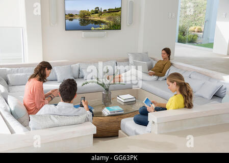 Family in living room busy in different activities Stock Photo ...
