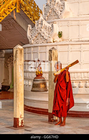 Monk ringing bell, Yangon Stock Photo - Alamy