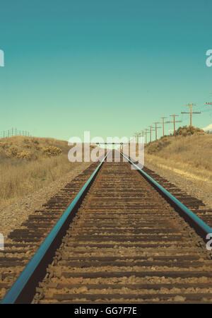 Perspective view of empty train tracks and concrete platform under ...