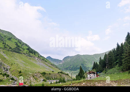 Photo of green capra peak, a road and a small river in fagaras ...